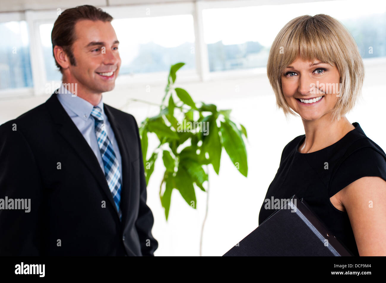 Smiling faces in office today. Boss passing by her secretary Stock ...