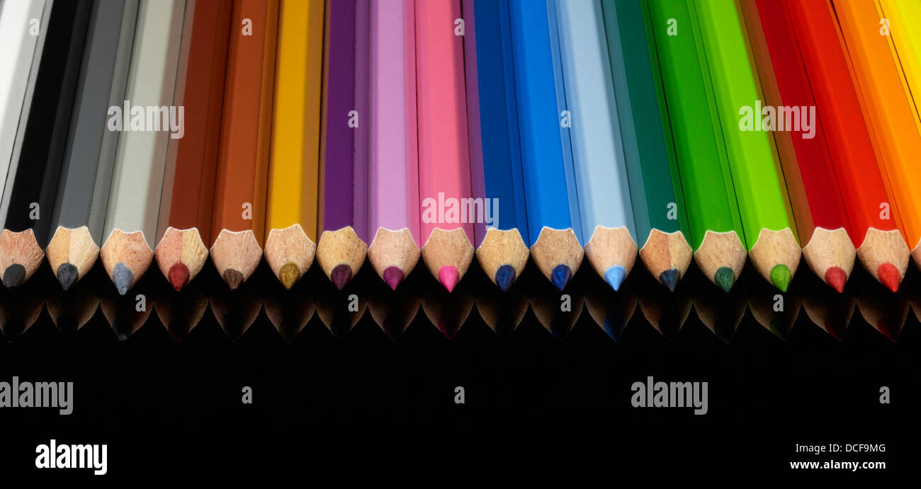 lots of colorful pencils in black reflective back Stock Photo - Alamy