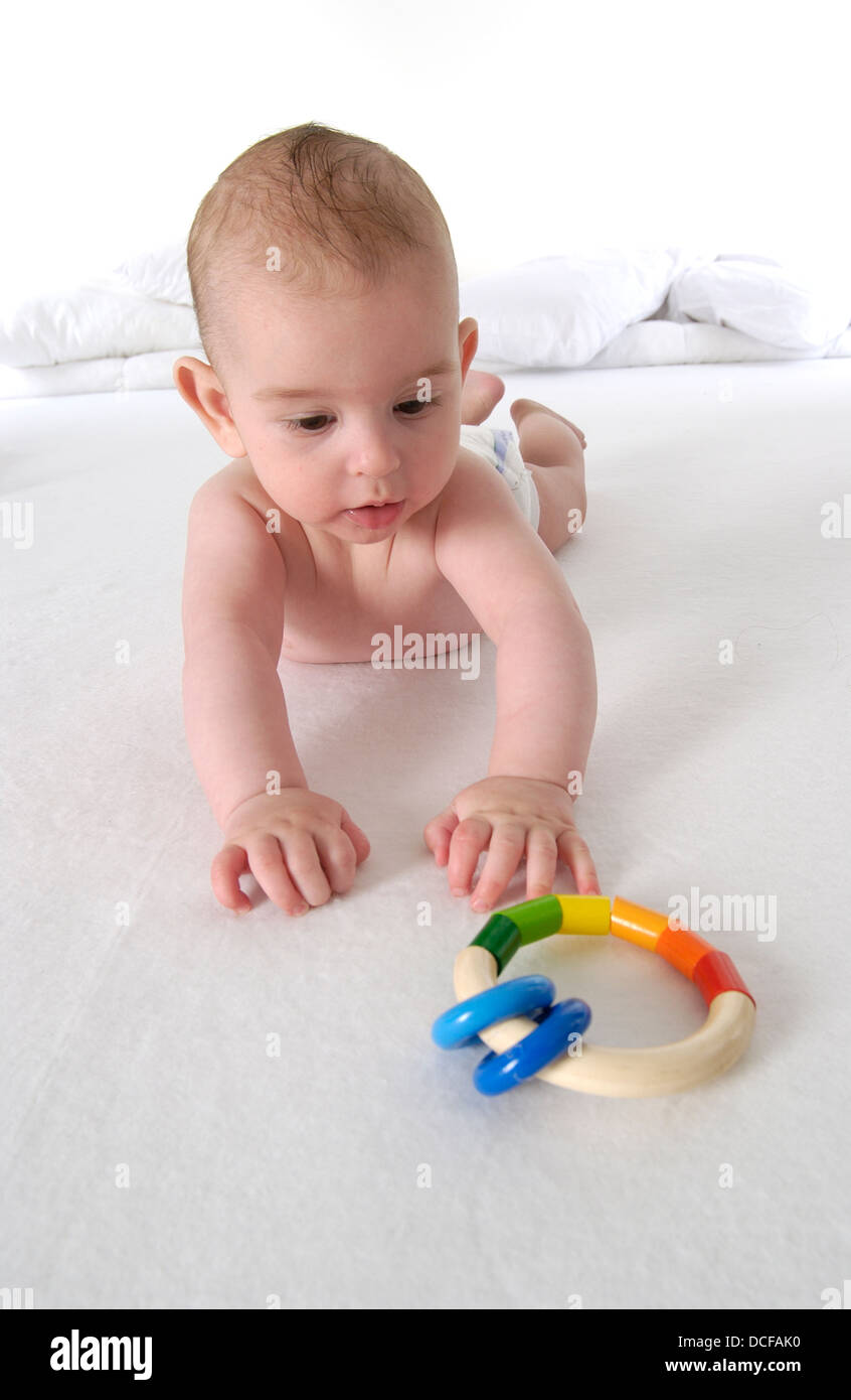 Baby boy reaching for a toy Stock Photo - Alamy