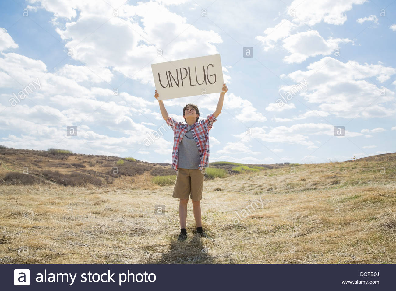 Portrait of little boy holding unplug sign outdoors Stock Photo - Alamy