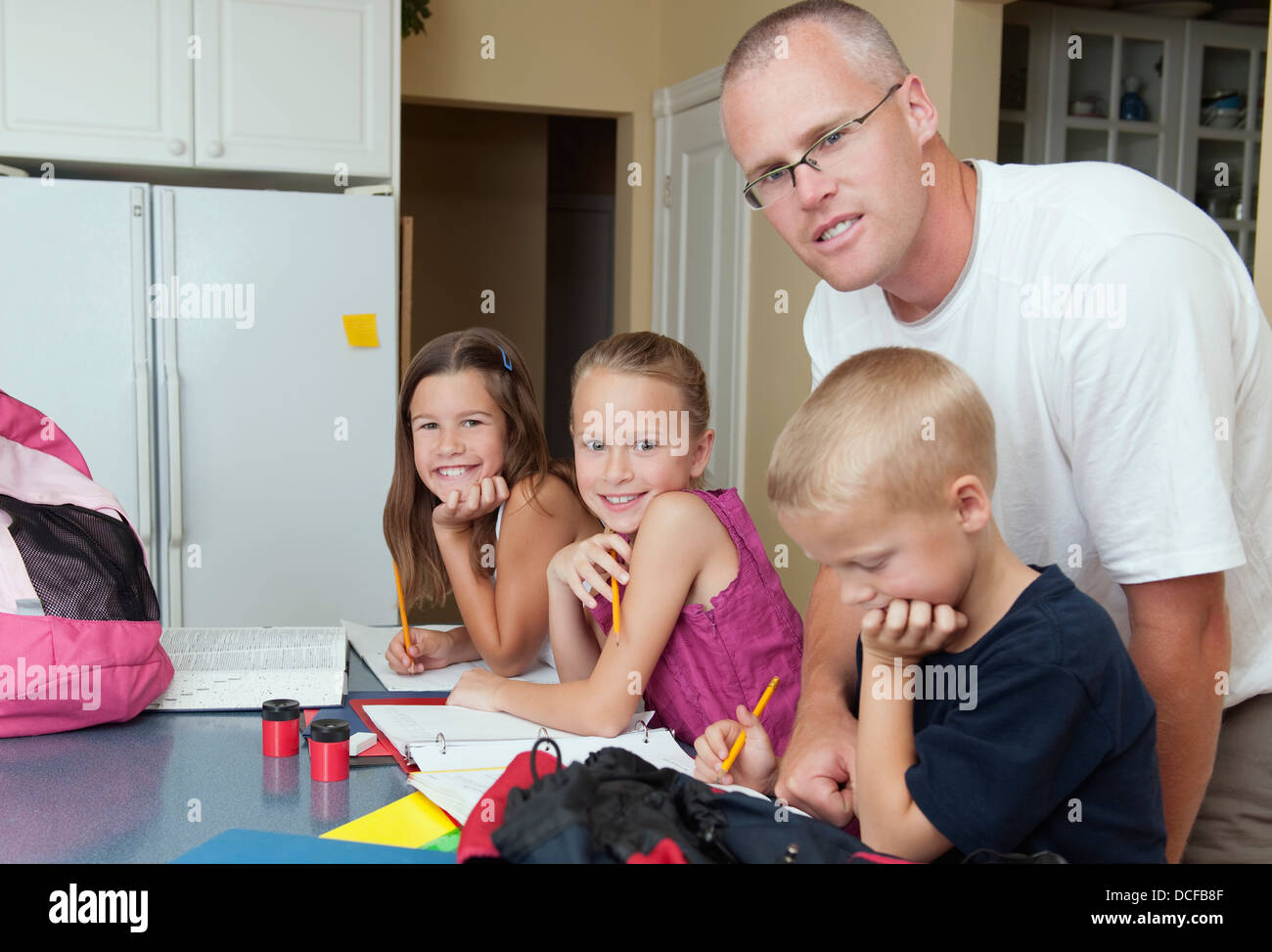 A Father Helping His Children With Their Homework Stock Photo - Alamy