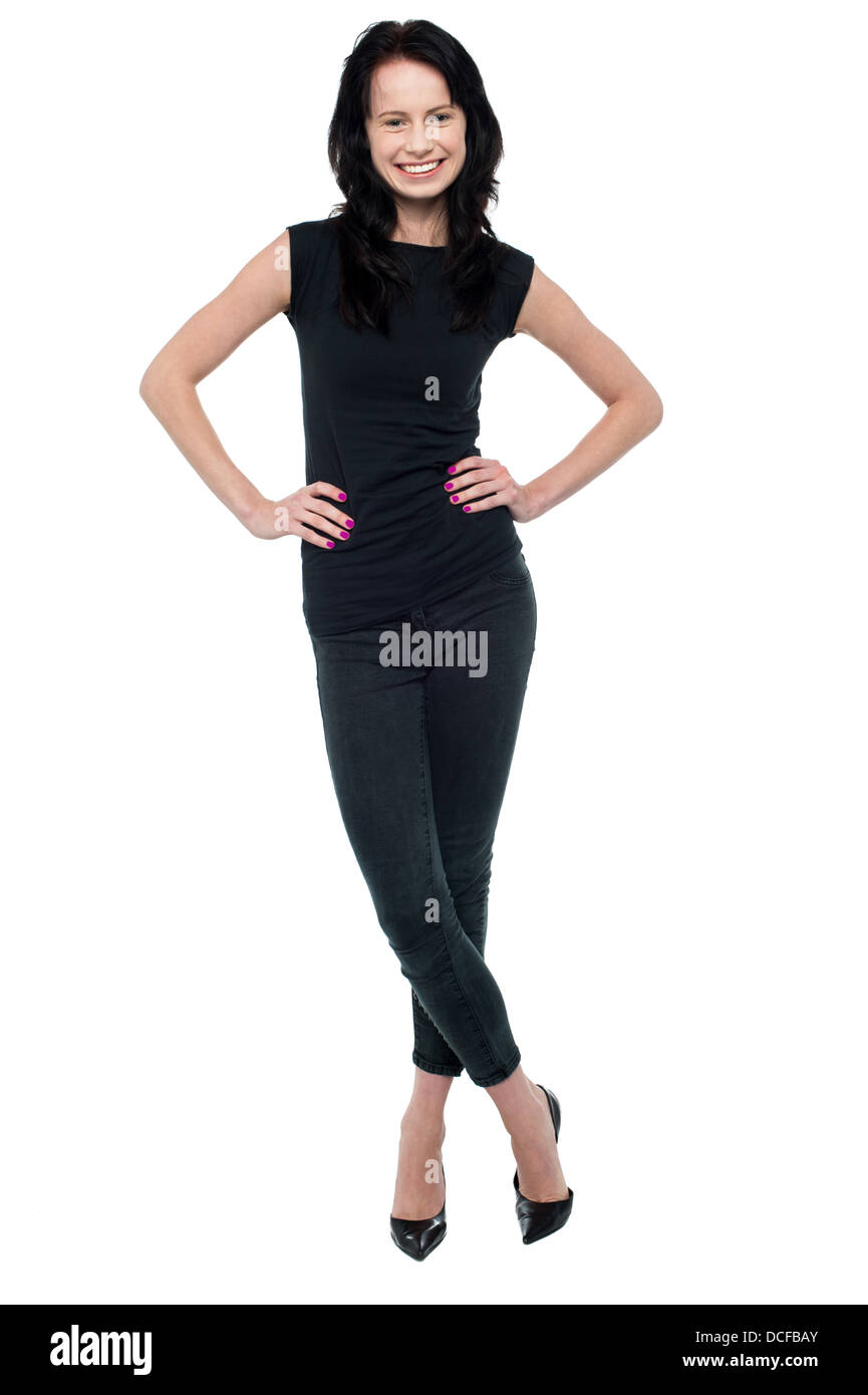 Attractive young lady posing with hands on her waist and legs crossed ...