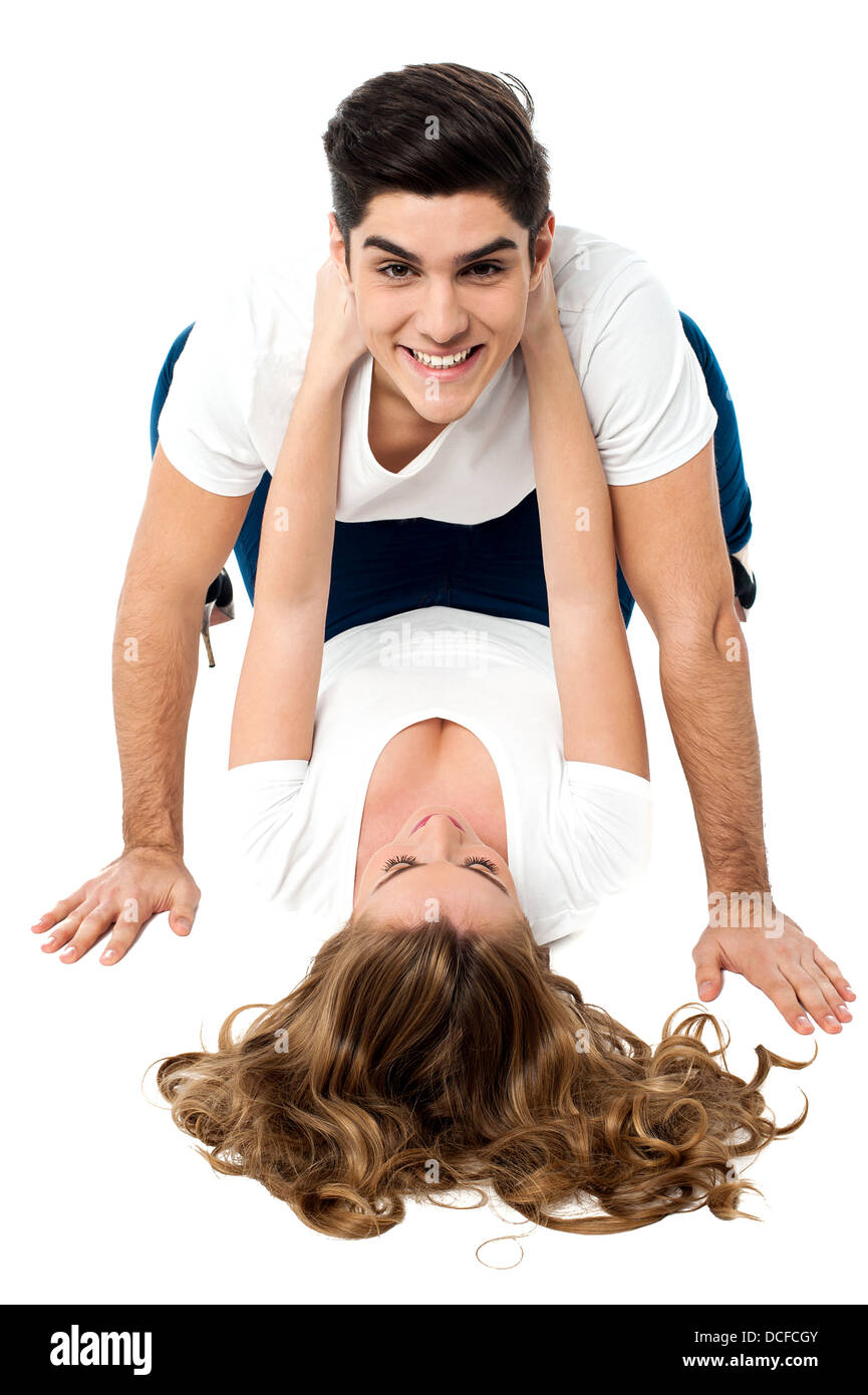 Charming young woman lying on the floor and clinging on to her partner ...