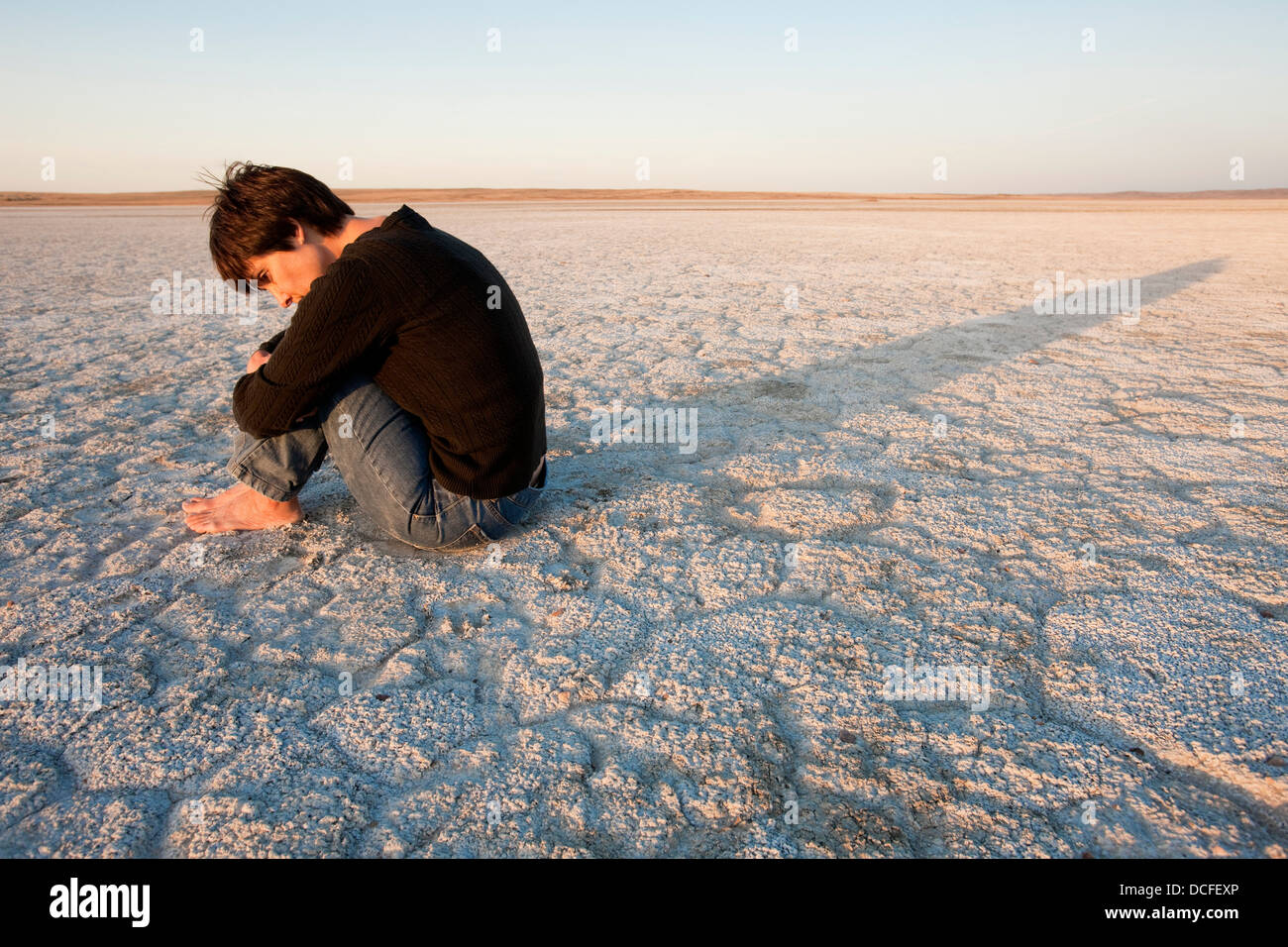 Woman Sitting In Desert Looking Sad Stock Photo - Alamy
