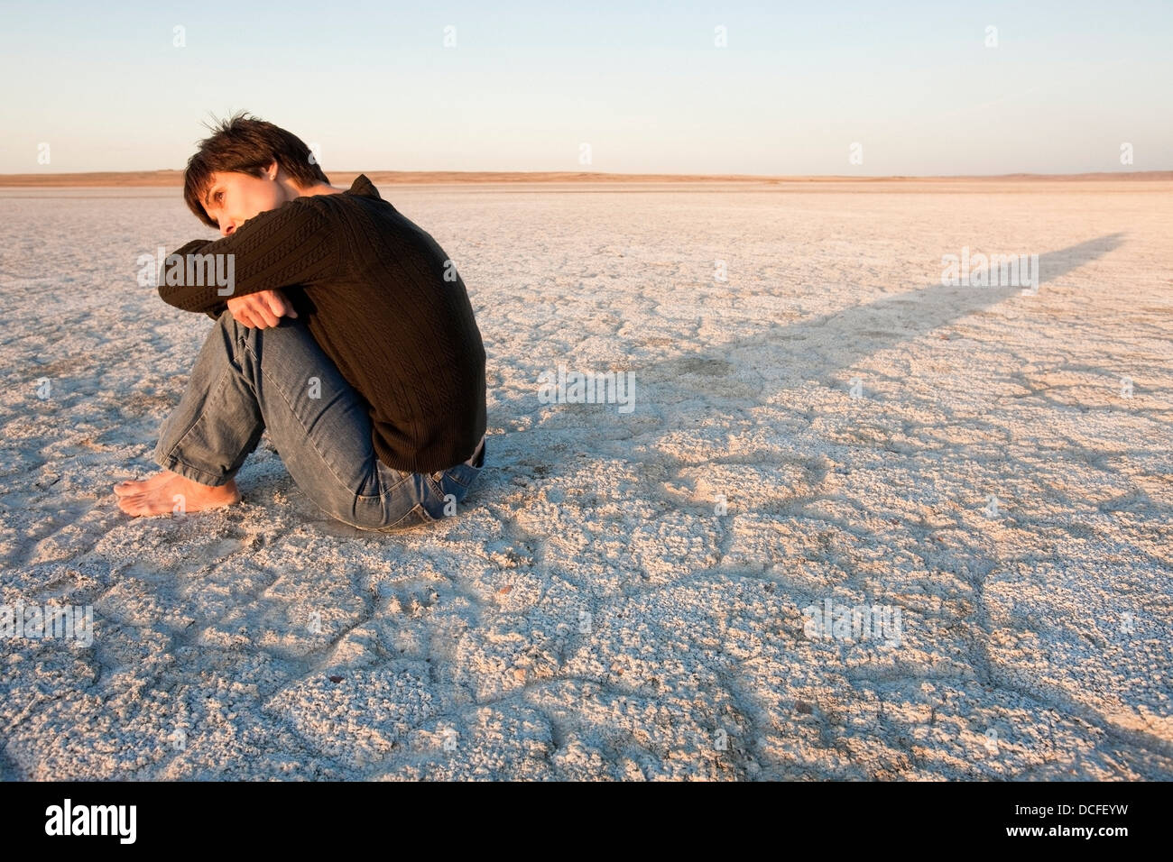 Woman Sitting In Desert Looking Sad Stock Photo - Alamy