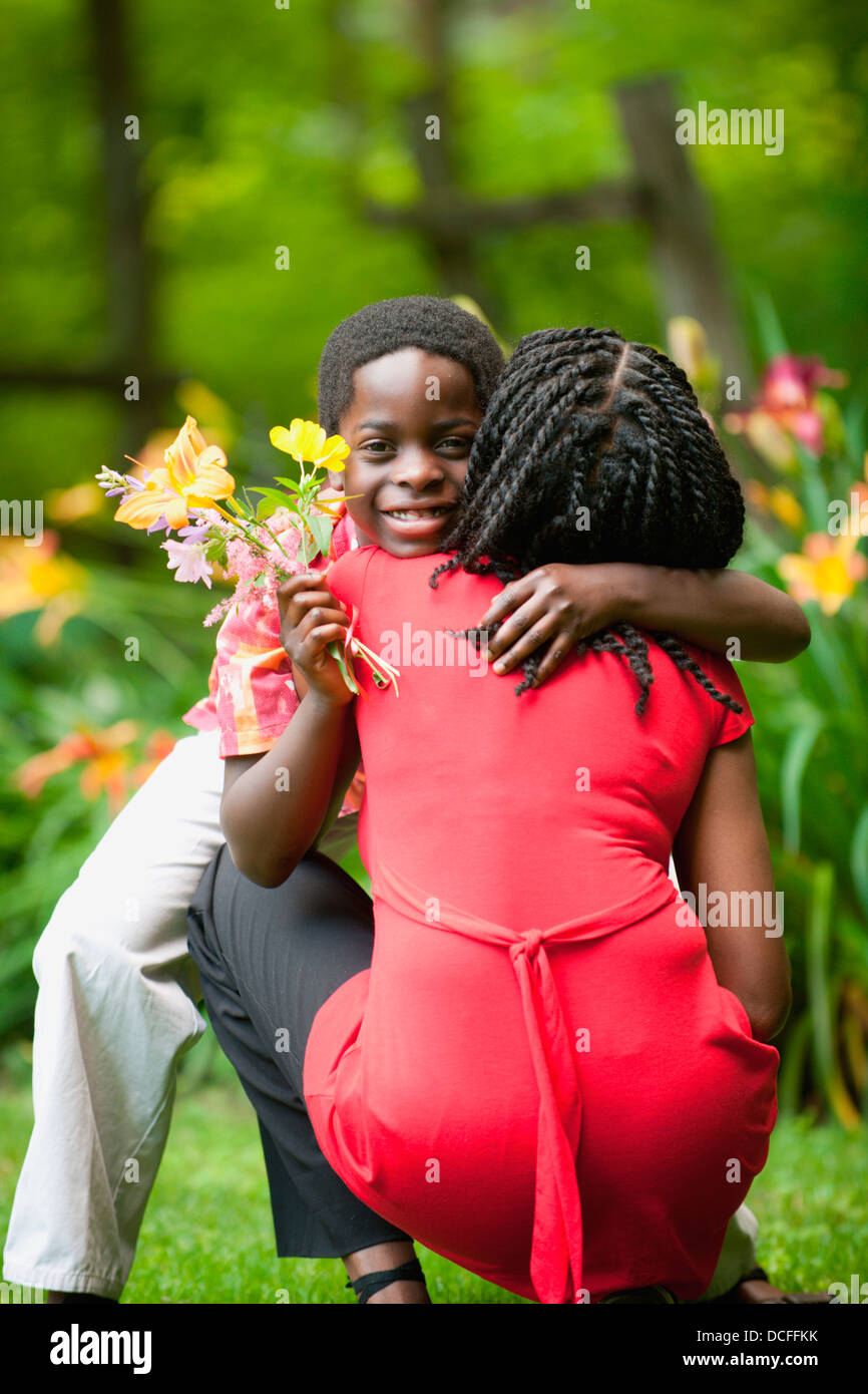 A Boy Giving His Mother Flowers Stock Photo - Alamy