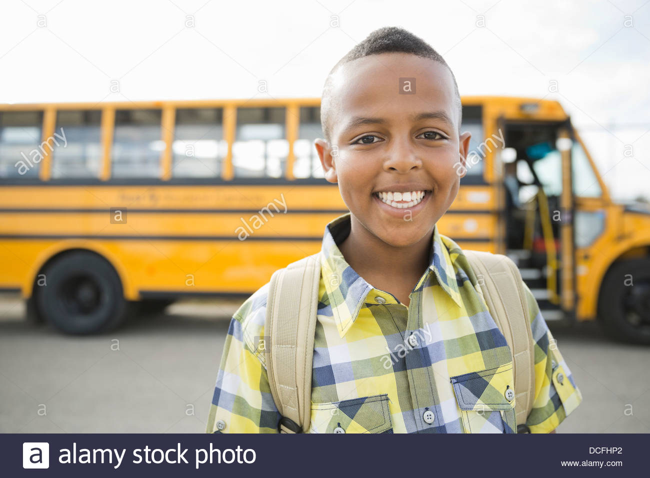 Portrait of schoolboy in front of school bus Stock Photo - Alamy