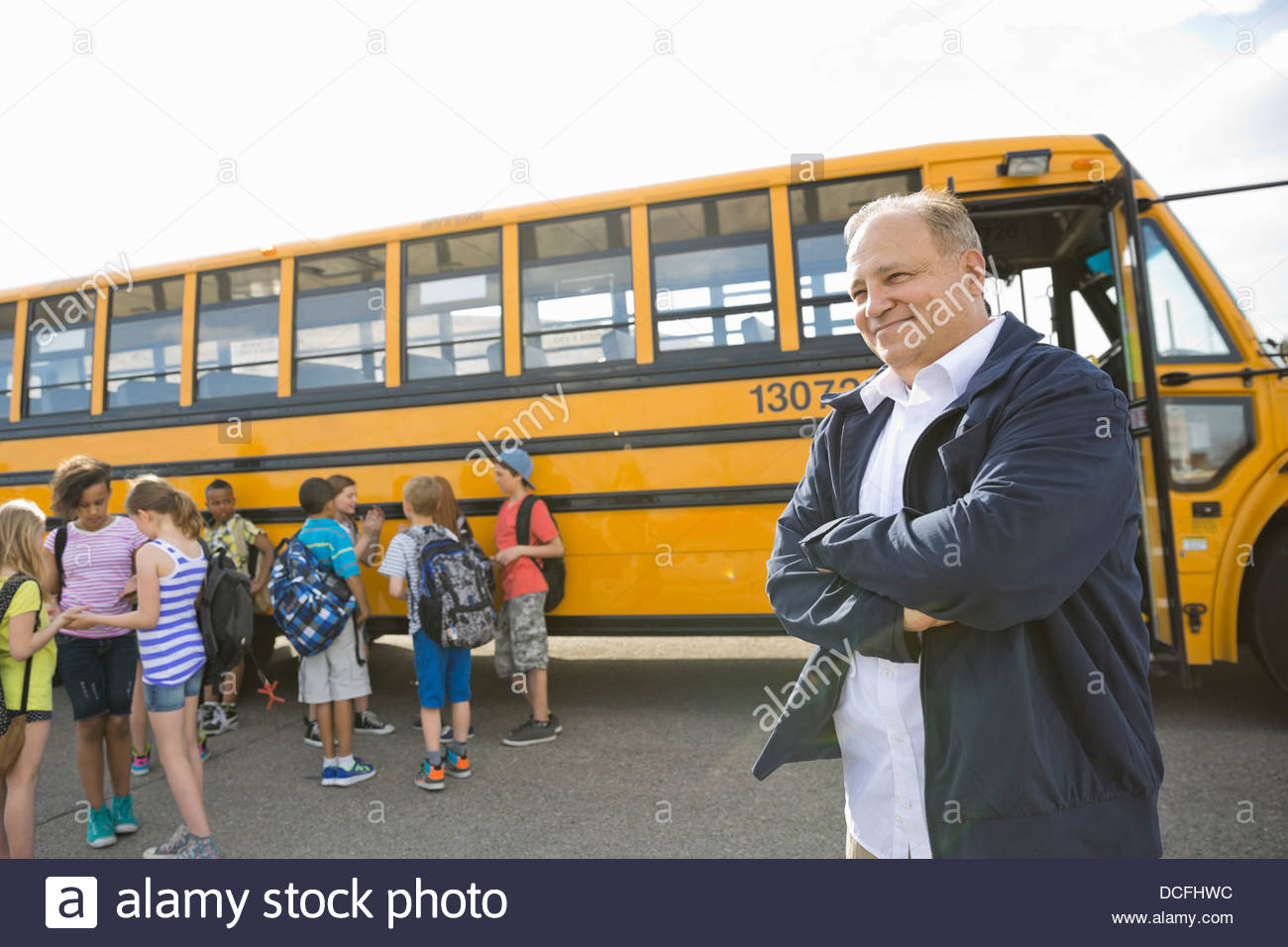 Teacher and students standing by school bus Stock Photo - Alamy