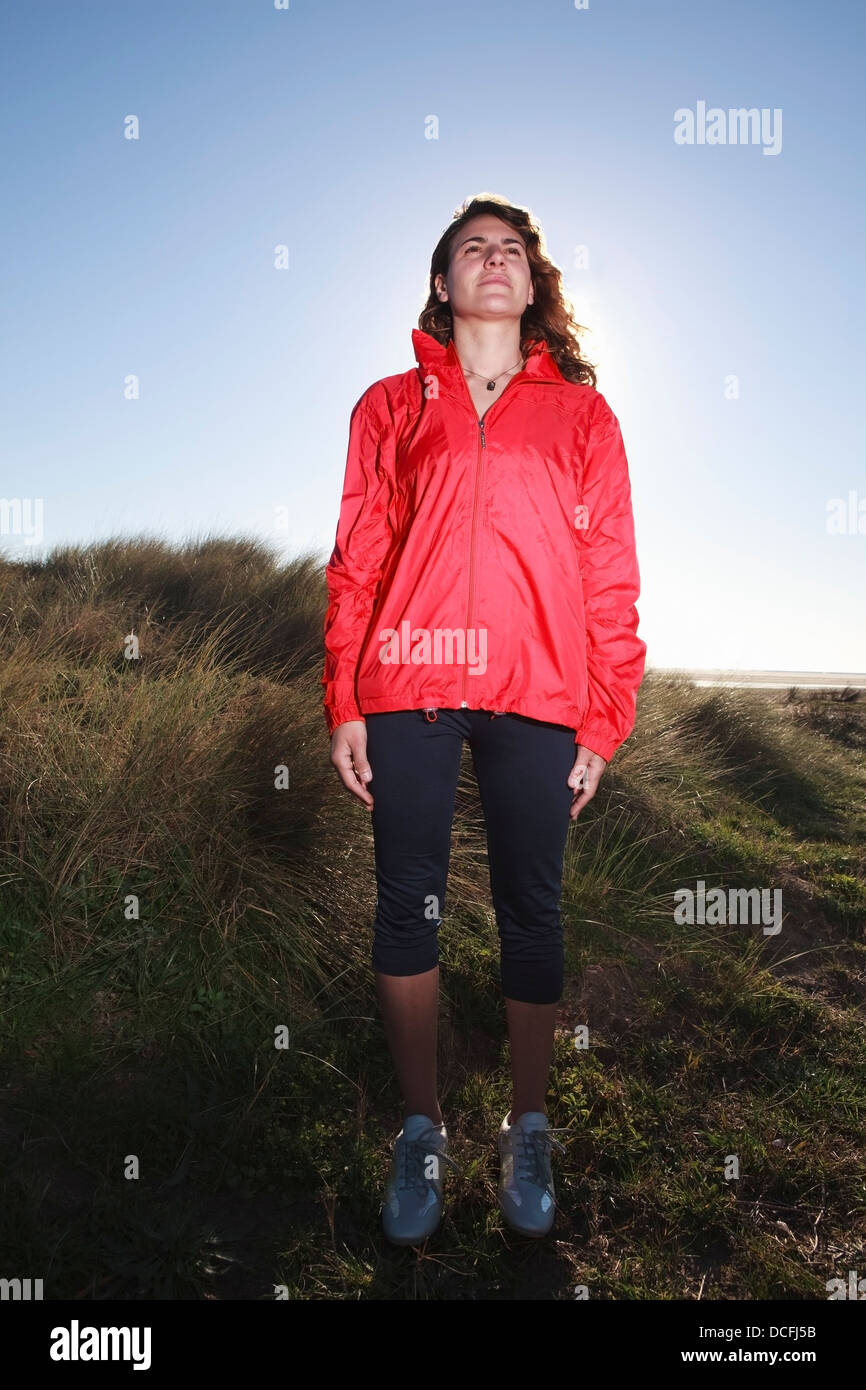 Female Runner Standing In Field Taking A Break Stock Photo - Alamy