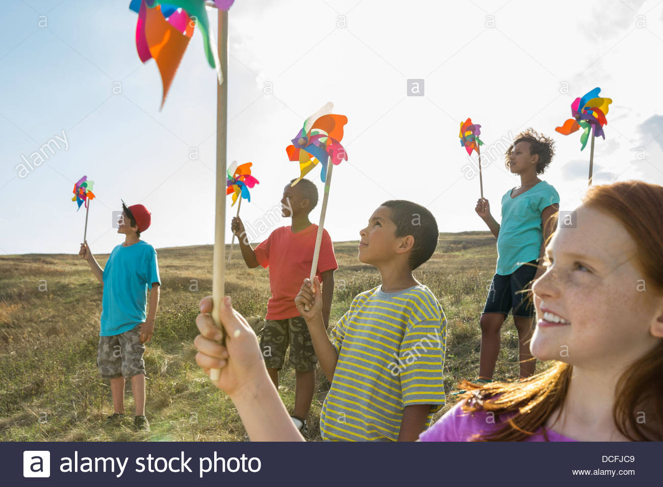 Smiling children holding pinwheels up Stock Photo - Alamy
