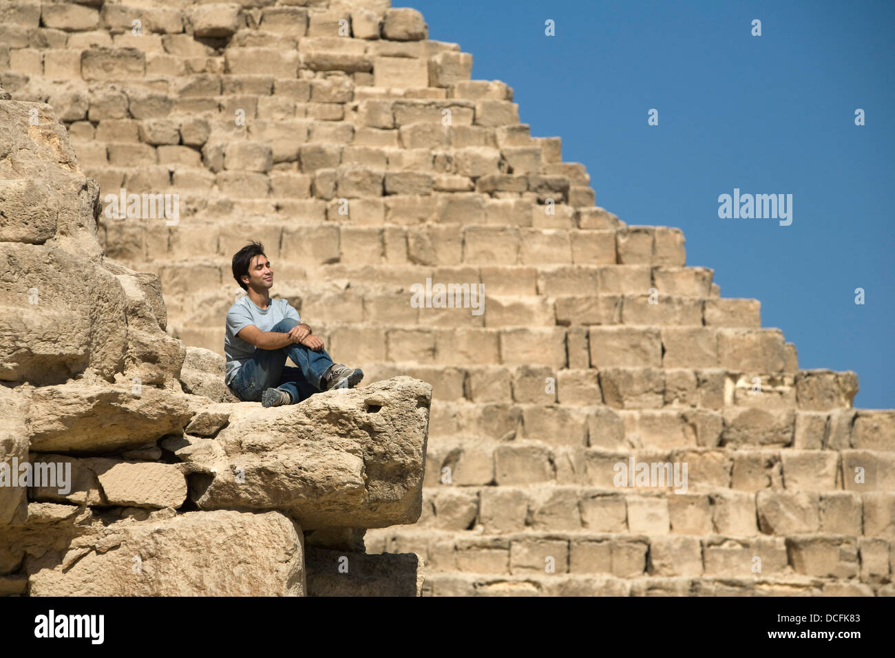 Man Sitting On Part Of A Pyramid In The Desert; Cairo,Egypt,Africa ...
