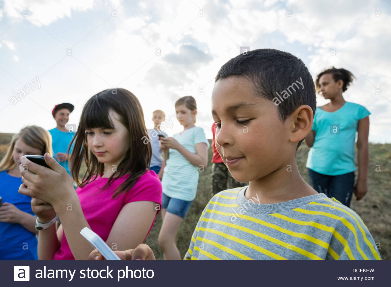 Group of kids using smart phones outdoors Stock Photo - Alamy