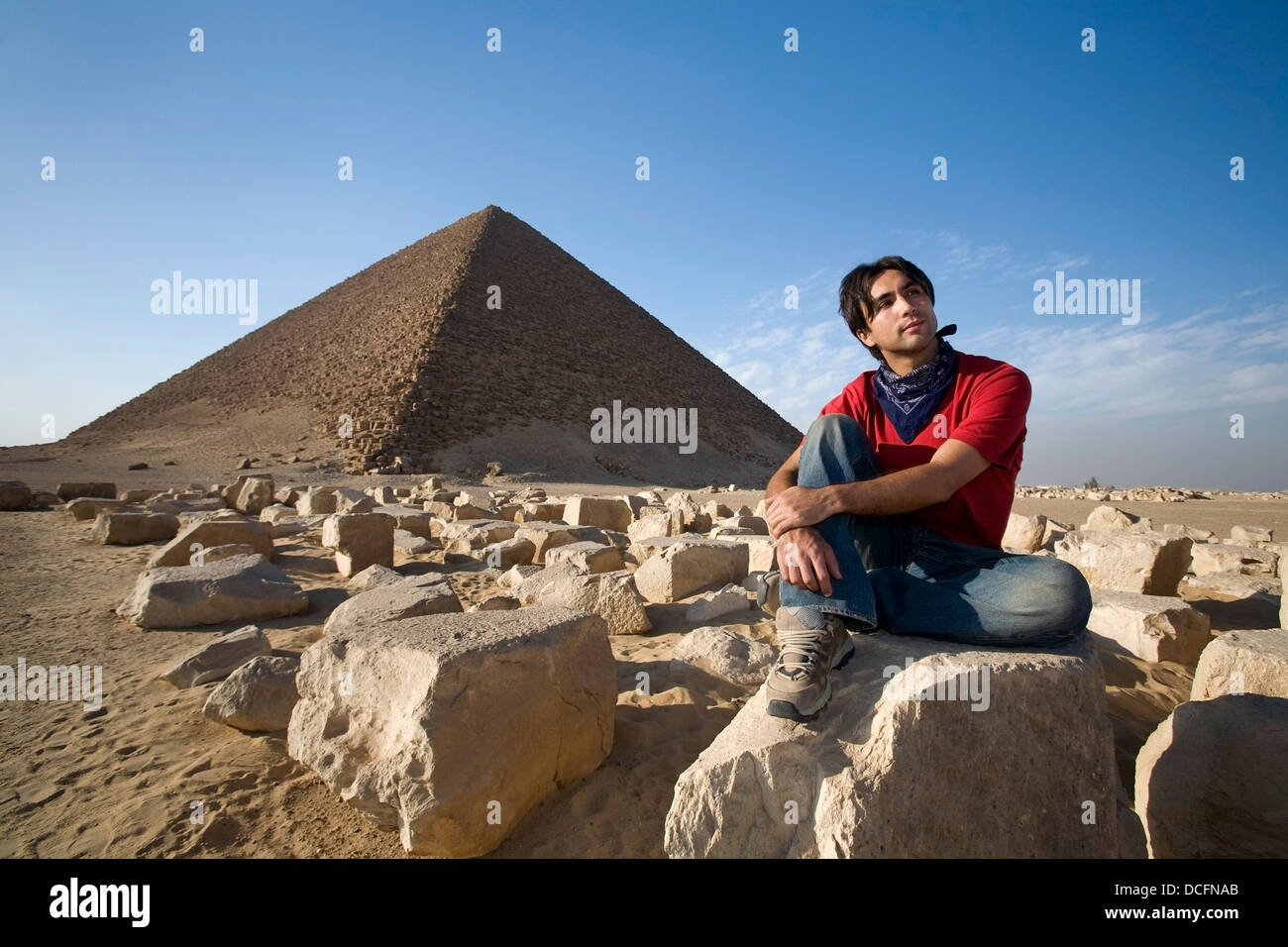 A Man Sitting Near A Pyramid In The Desert Stock Photo - Alamy