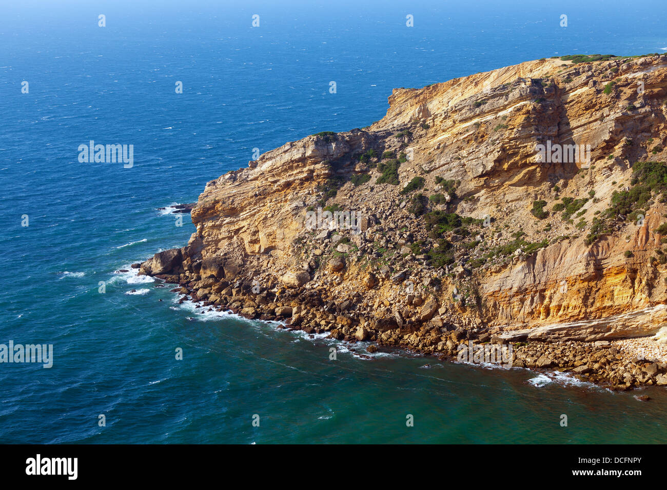 View of a rugged coastline with steep barren cliffs falling down to a ...