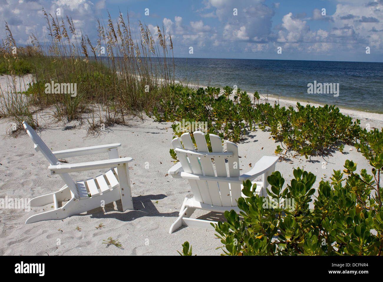 Two Adirondack chairs on a white sandy beach Stock Photo - Alamy