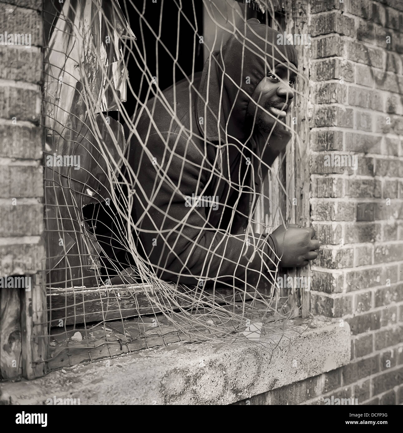Homeless man in the Bronx, New York City leans on the window ledge of ...