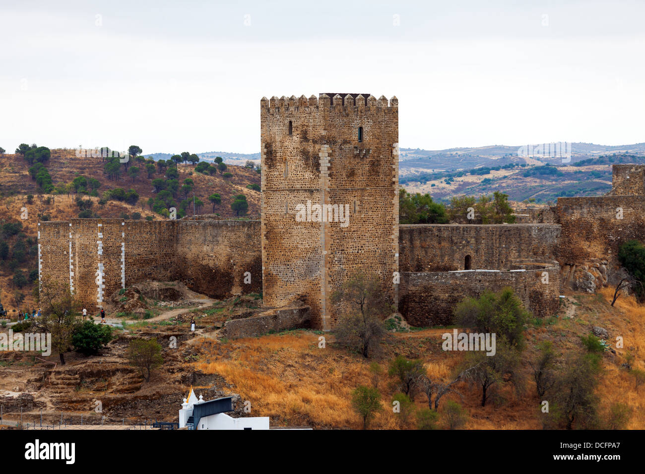 Fortified stone lookout tower with crenellations alongside a perimeter ...