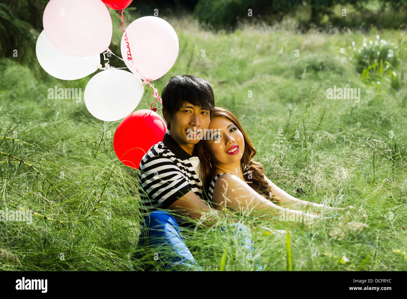 Horizontal photo of young adult couple, looking forward, sitting in the ...
