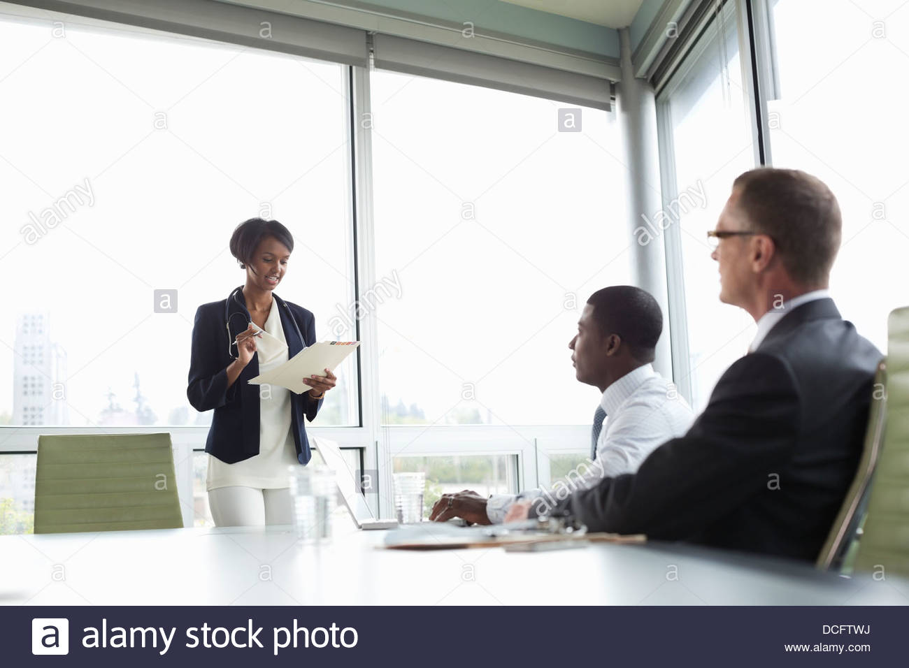 Female professional presenting to colleagues Stock Photo - Alamy