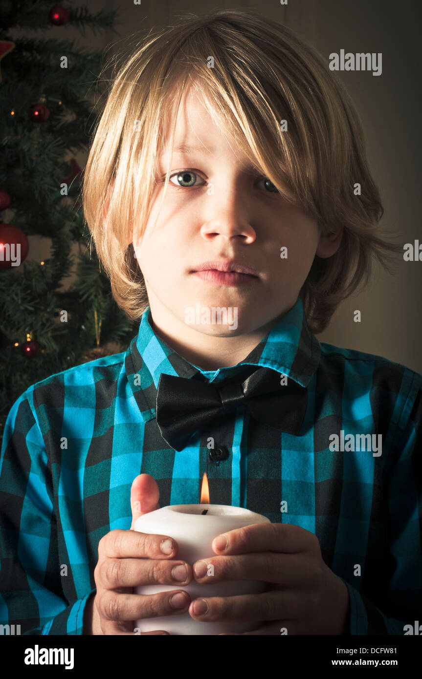 Boy holding a candle and hoping Stock Photo - Alamy
