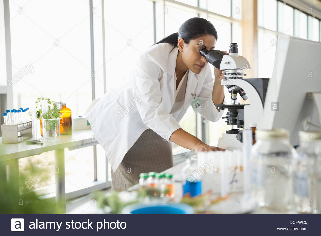 Female scientist looking through microscope hi-res stock photography ...