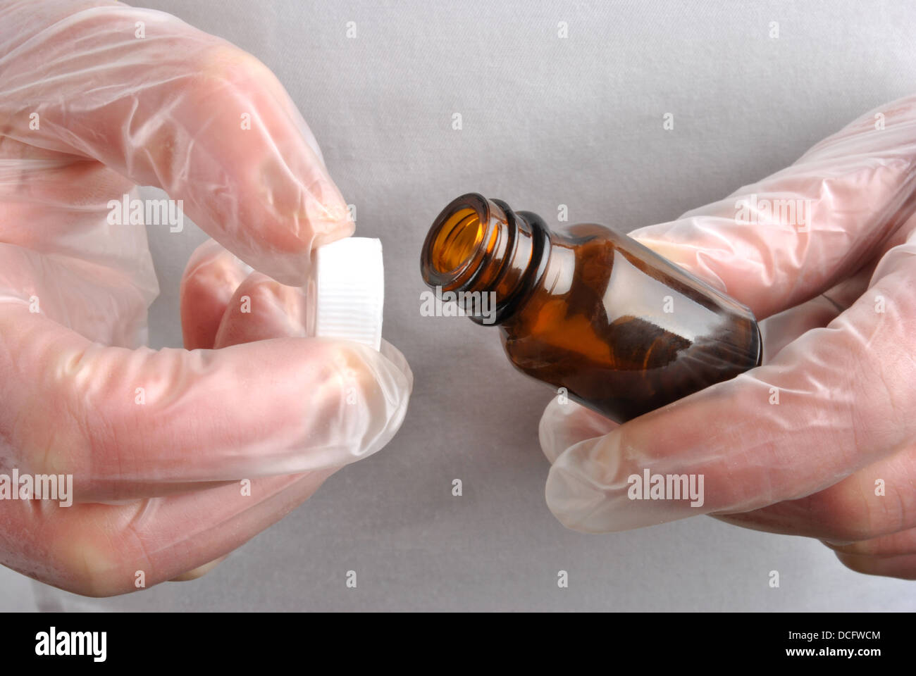 medical staff with disposable gloves and a glass bottle Stock Photo - Alamy