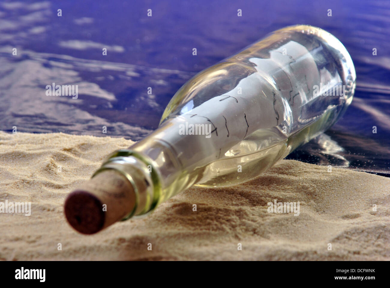 bottle message on a sandy beach with a letter Stock Photo - Alamy