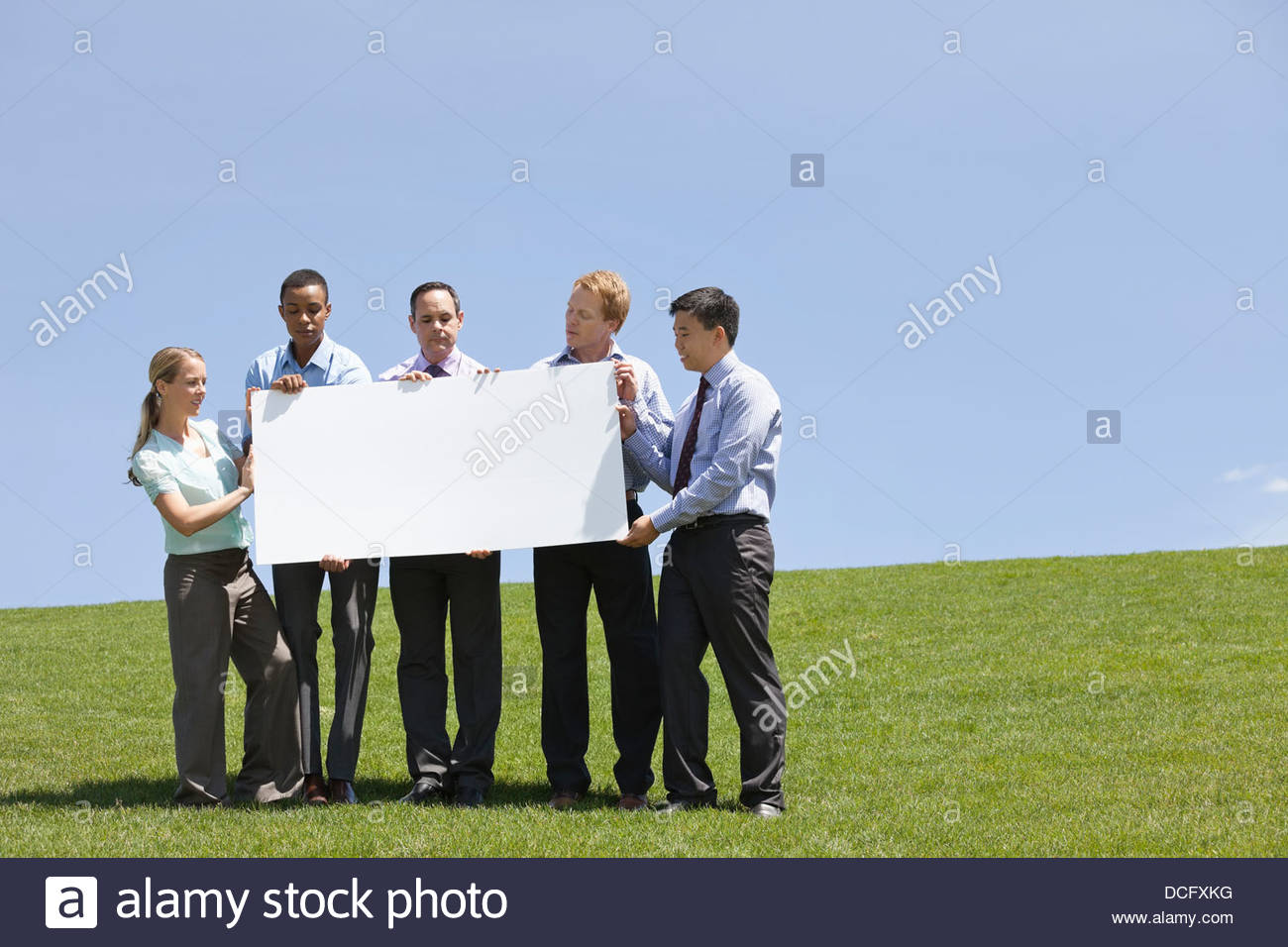 Group of business people displaying blank sign together Stock Photo - Alamy