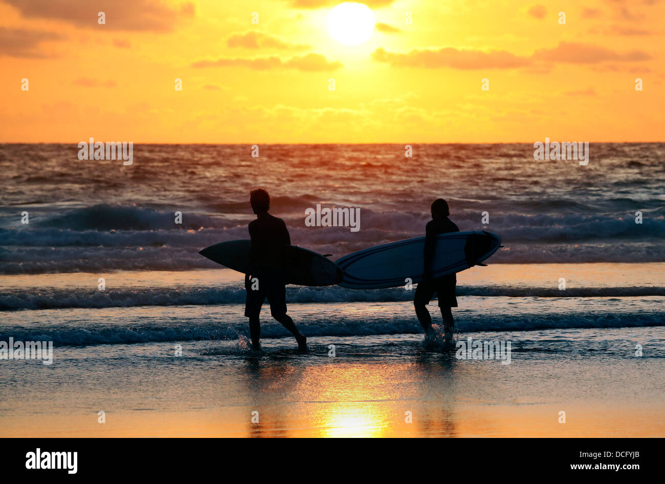 Surfers on sunset Stock Photo - Alamy