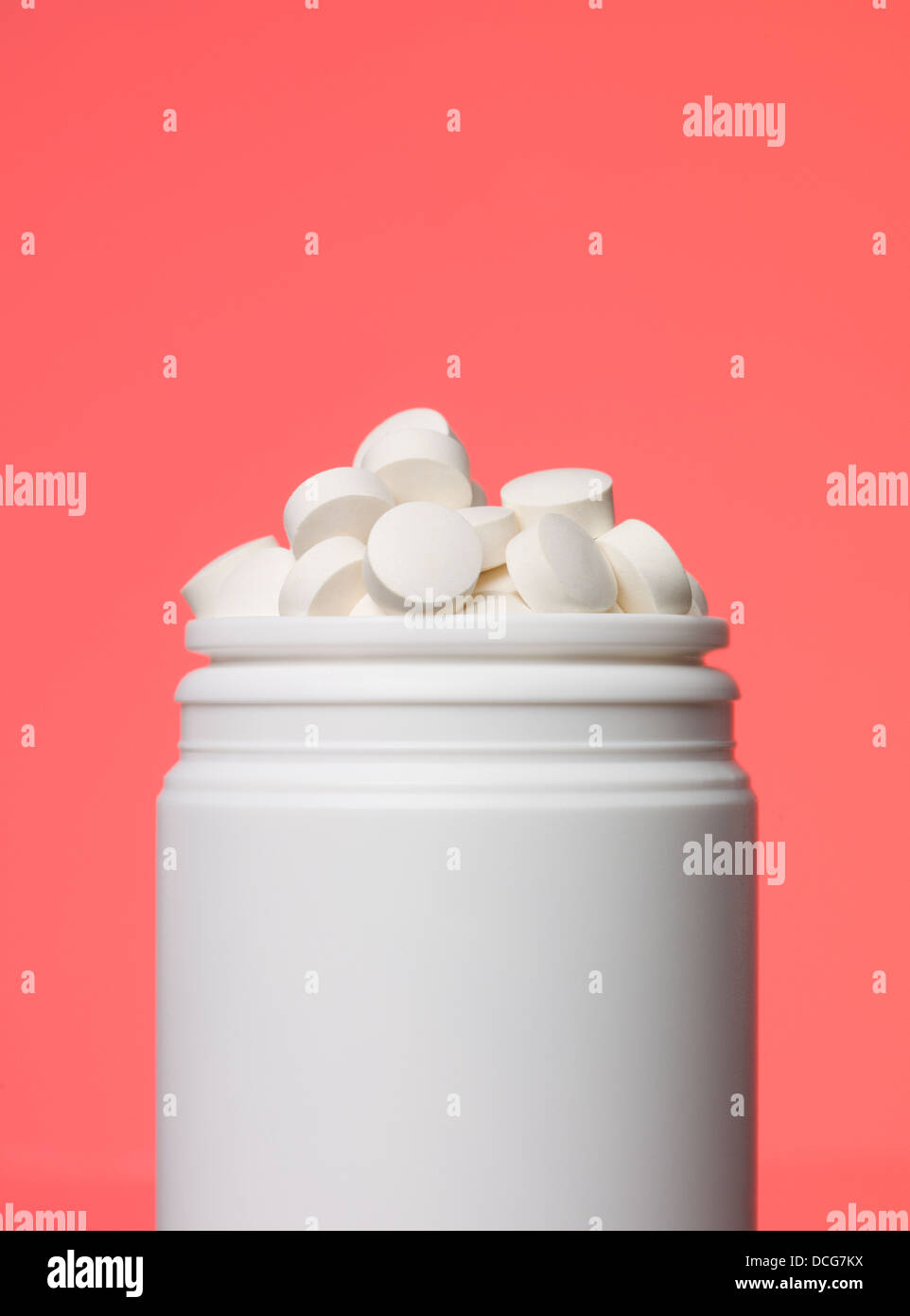 Can with pills towards red background Stock Photo - Alamy