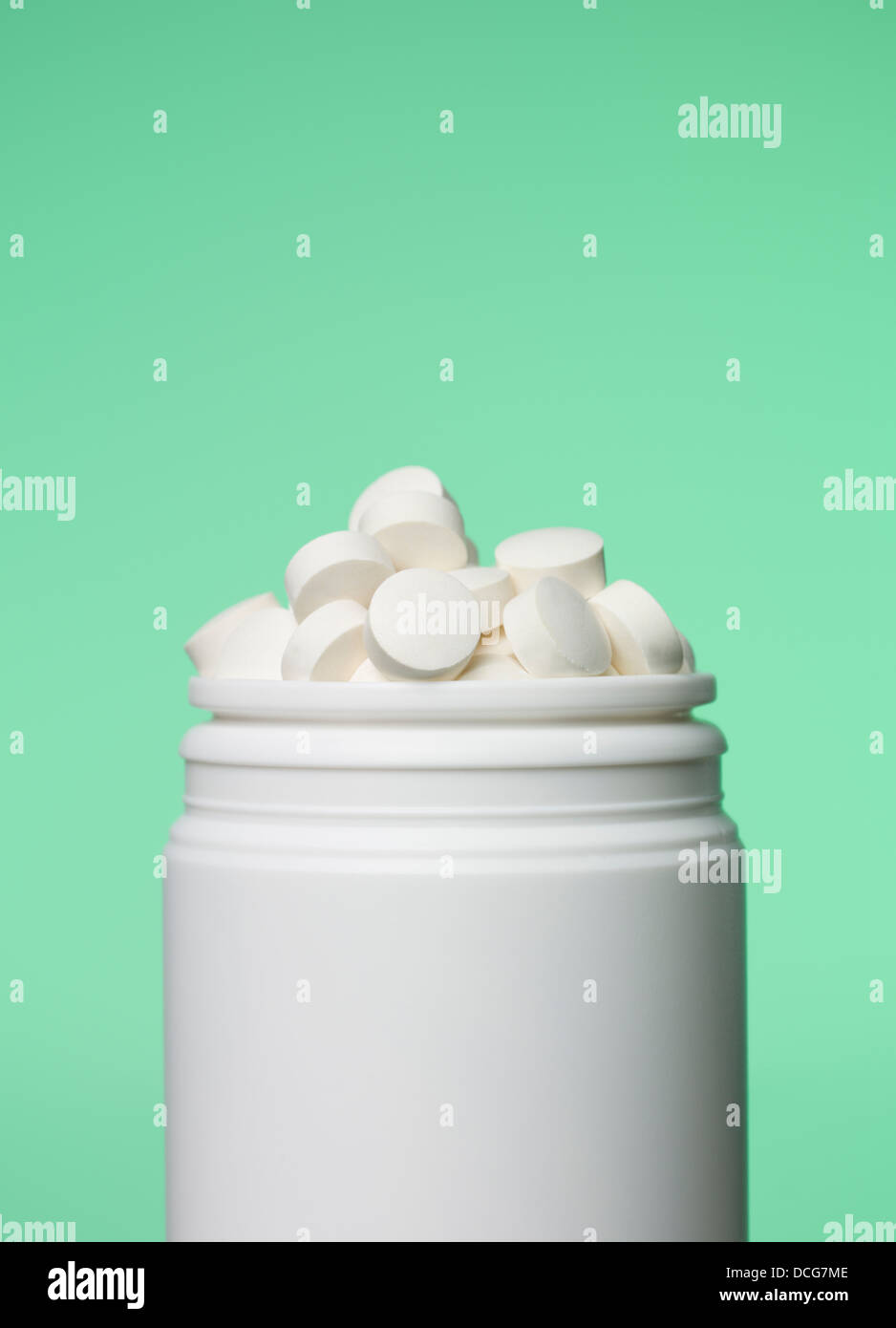 Can of pills toward green background Stock Photo - Alamy