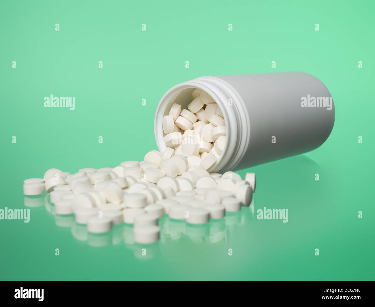 Can of pills toward green background Stock Photo - Alamy