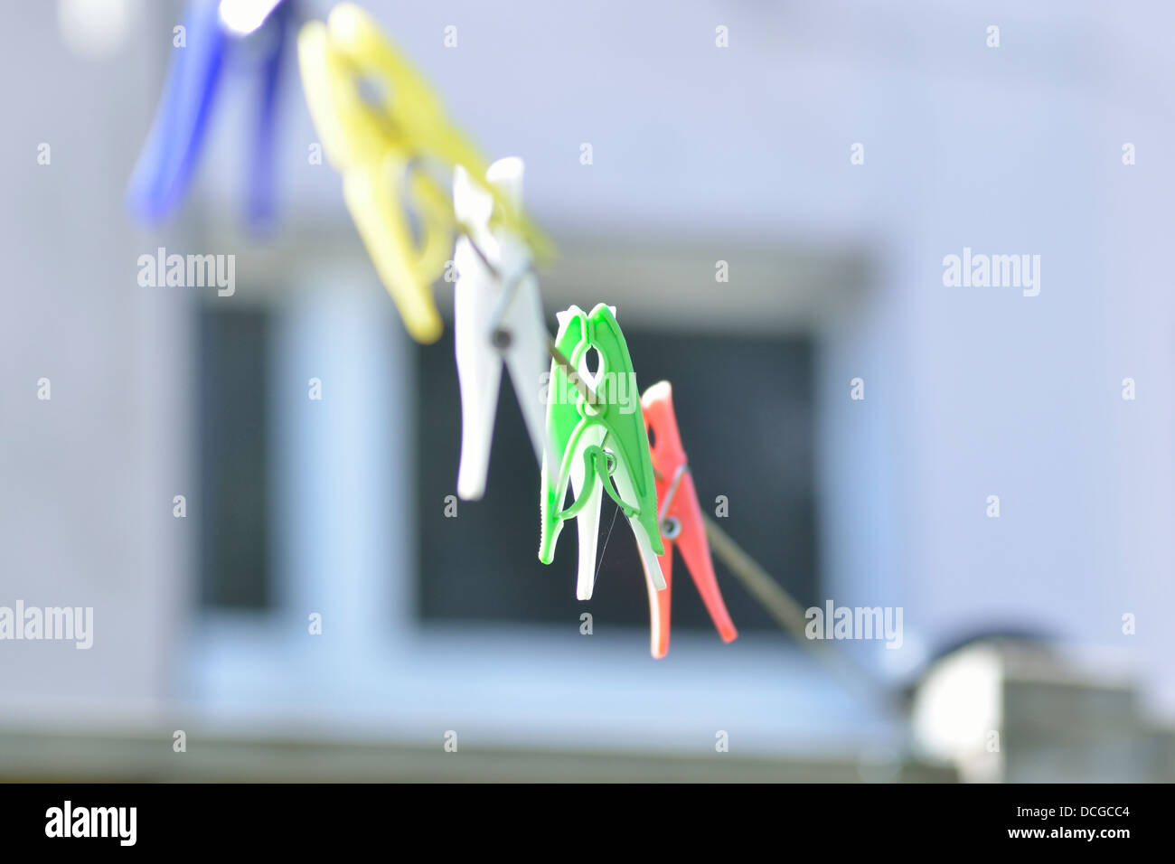 Assorted clothes pegs on a washing line Stock Photo - Alamy