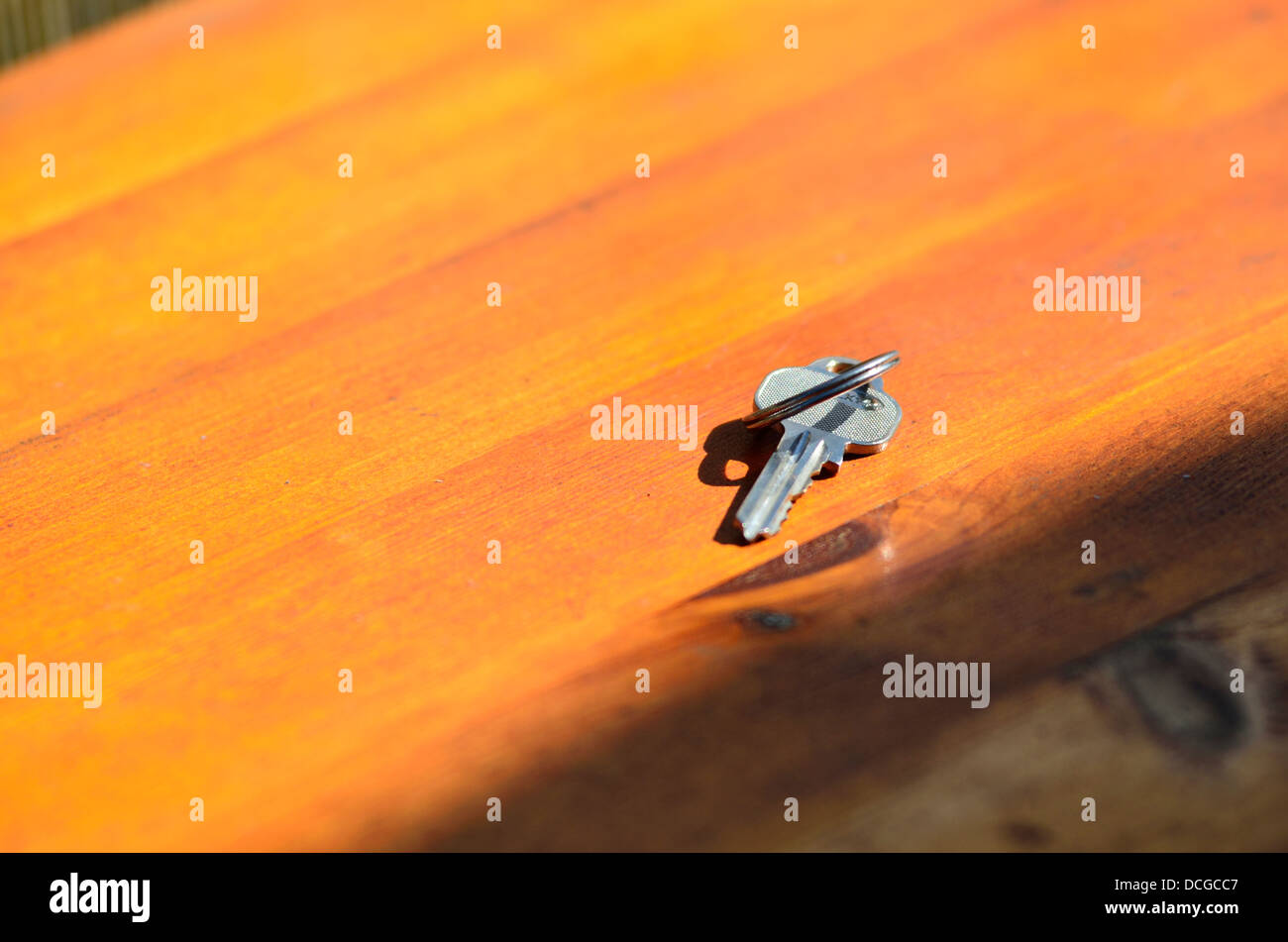 Silver key with fob on a wooden table Stock Photo - Alamy