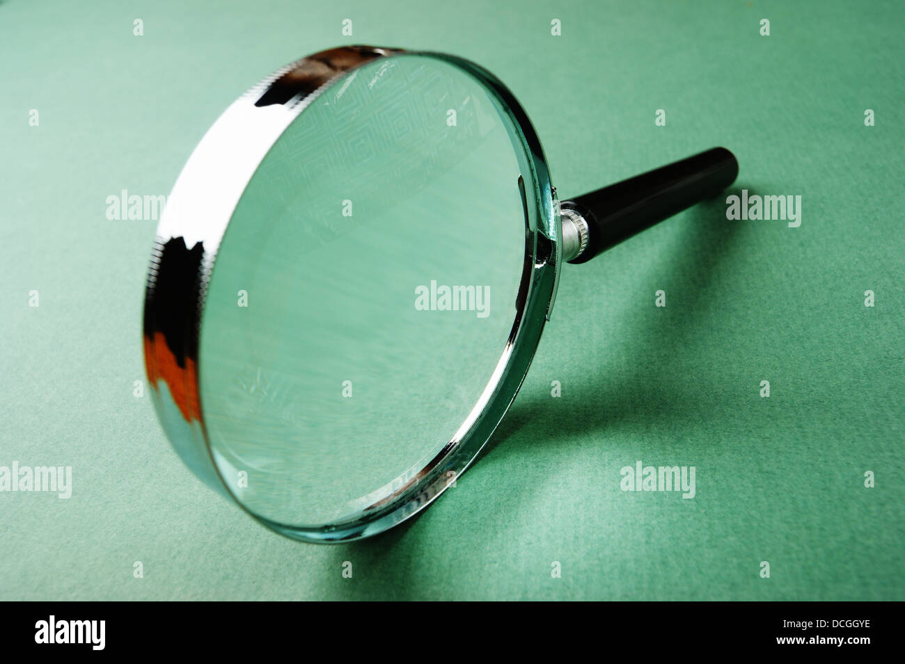 magnifying glass on green background Stock Photo - Alamy