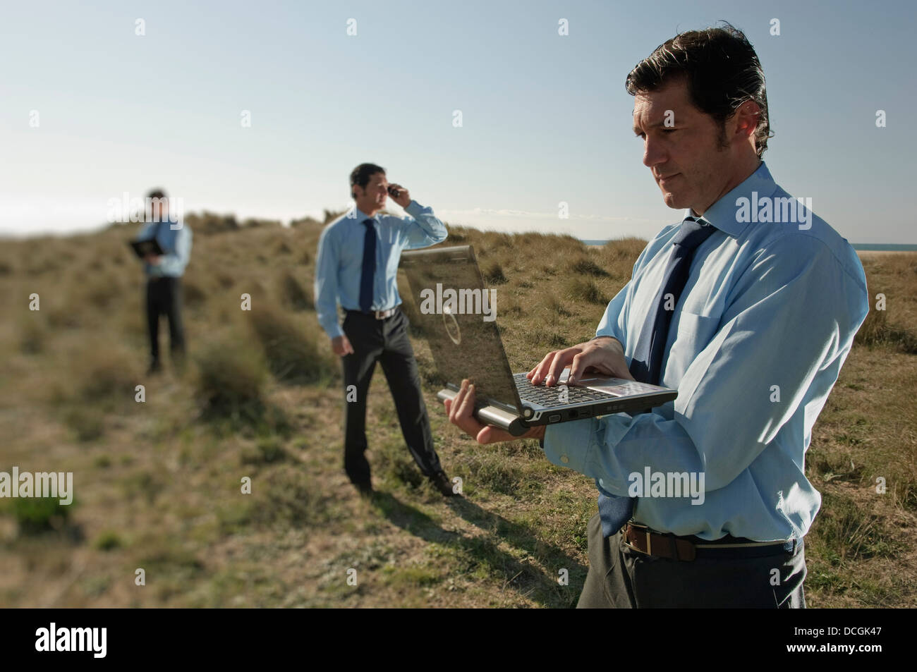 Businessmen In Field With Their Communications Technology Stock Photo ...