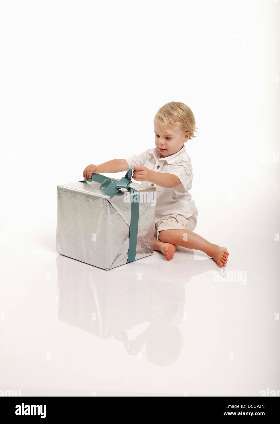 Toddler Unwrapping Gift Against White Background Stock Photo - Alamy