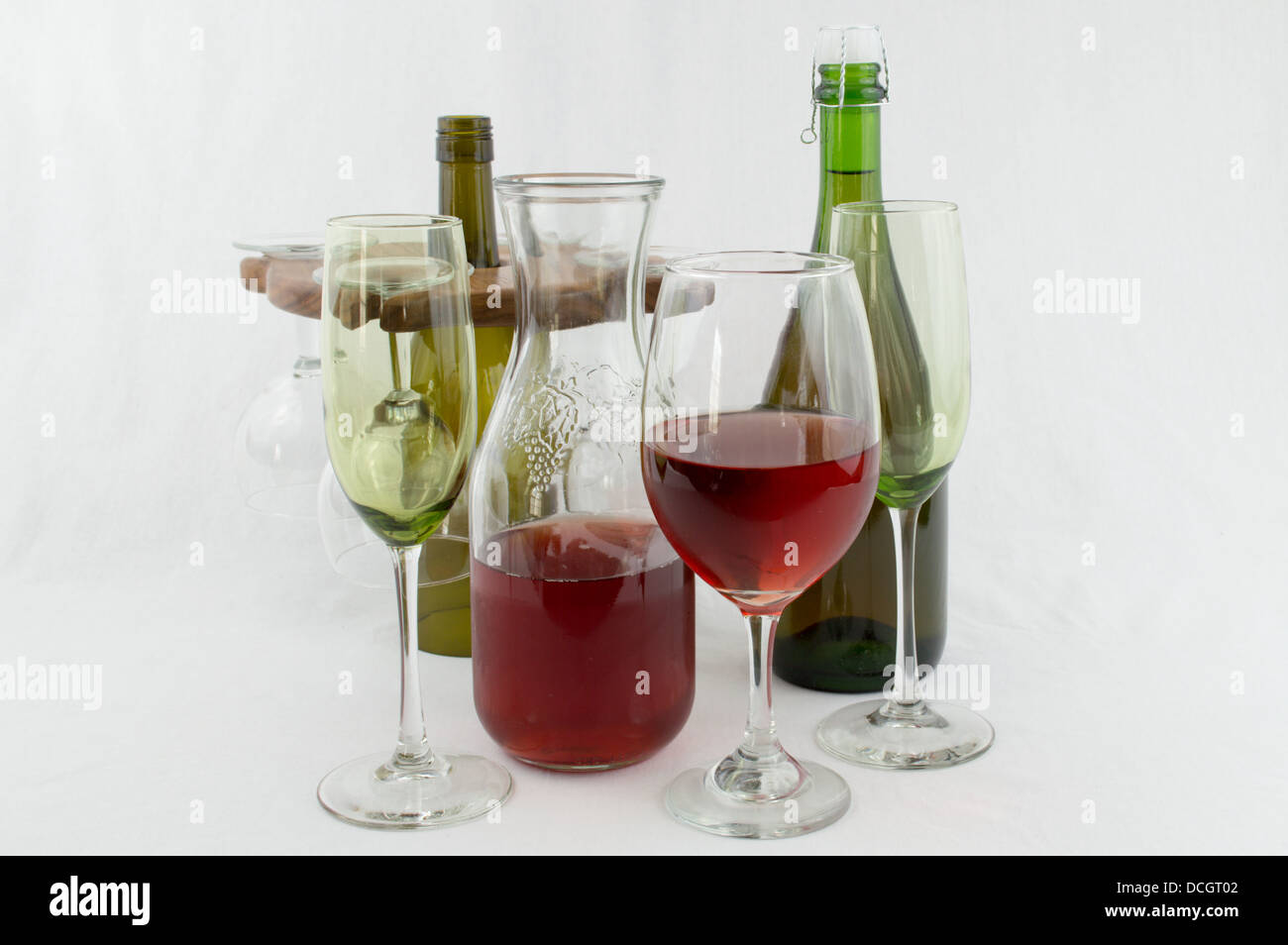 Half full decanter and wine glass with green champagne glasses and ...