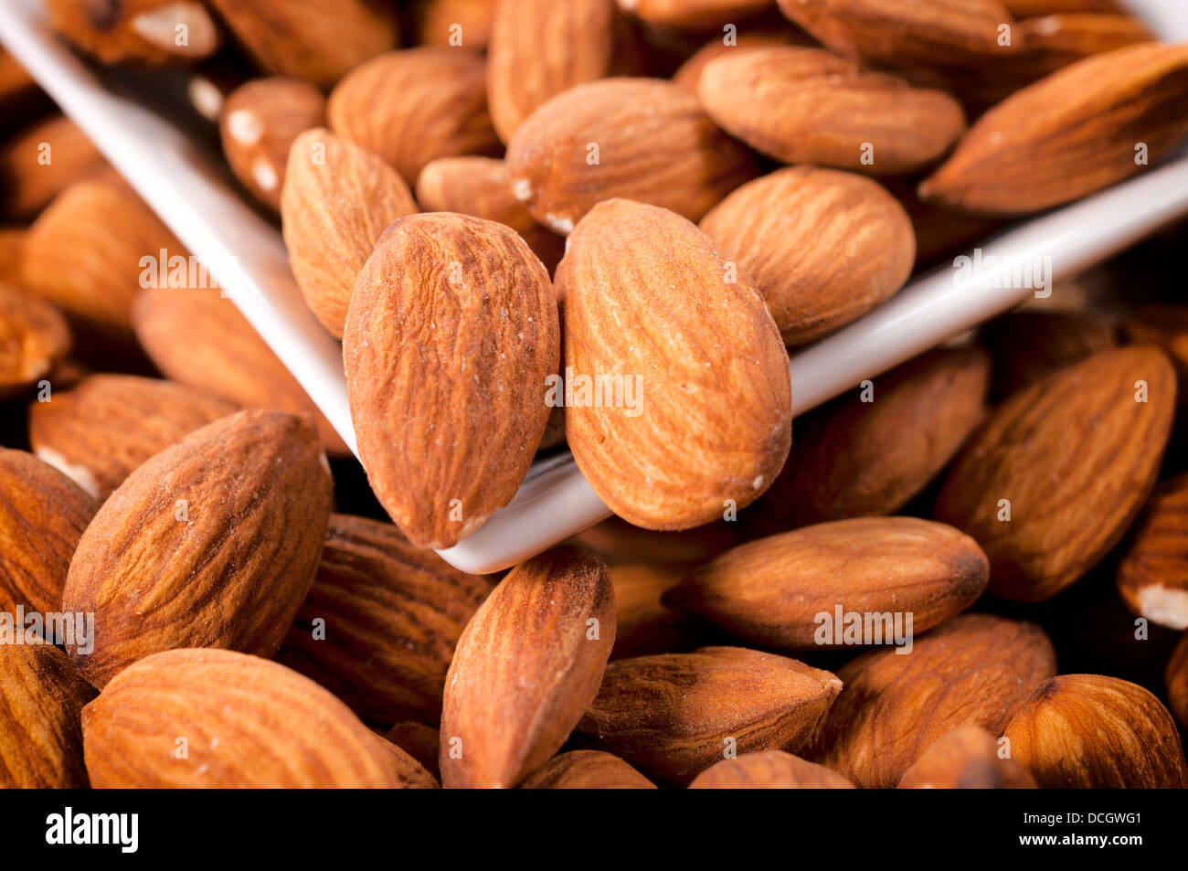 Large group of the raw almonds in white cup Stock Photo - Alamy