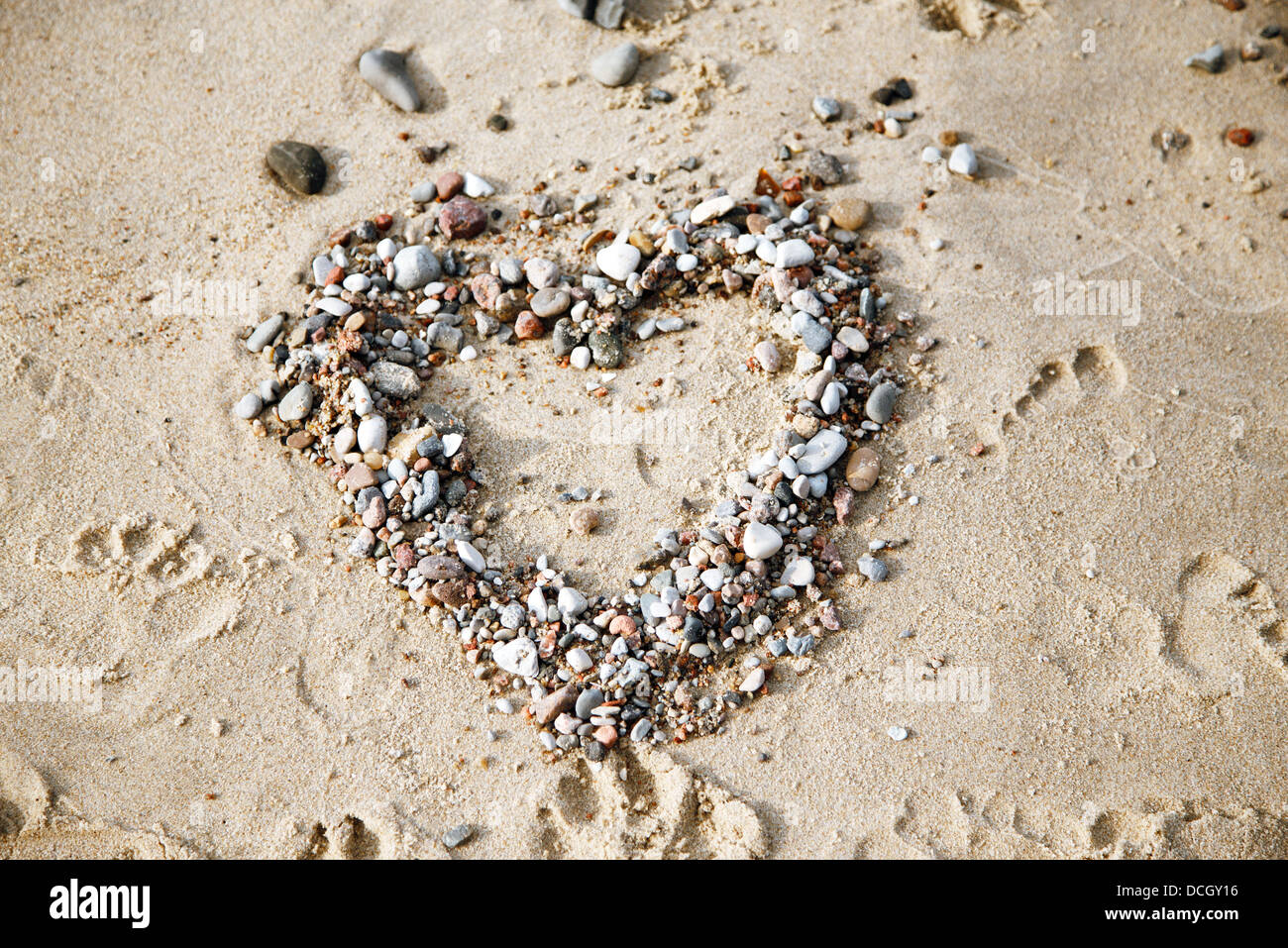 Heart shaped beach stones on wet sand Stock Photo - Alamy