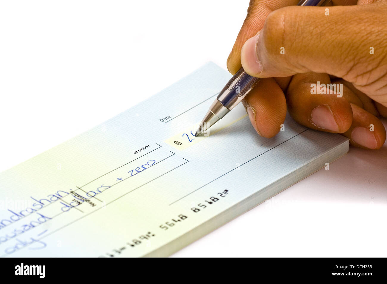 A hand signing a cheque Stock Photo - Alamy