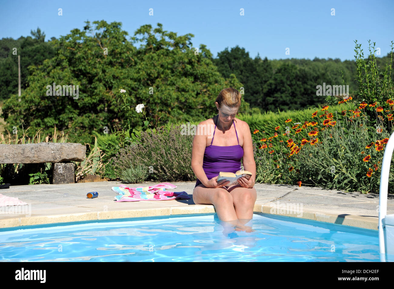 Woman Reading Book Beside Swimming Pool At A Holiday Gite At Frayssinet Le Gelat In The Lot