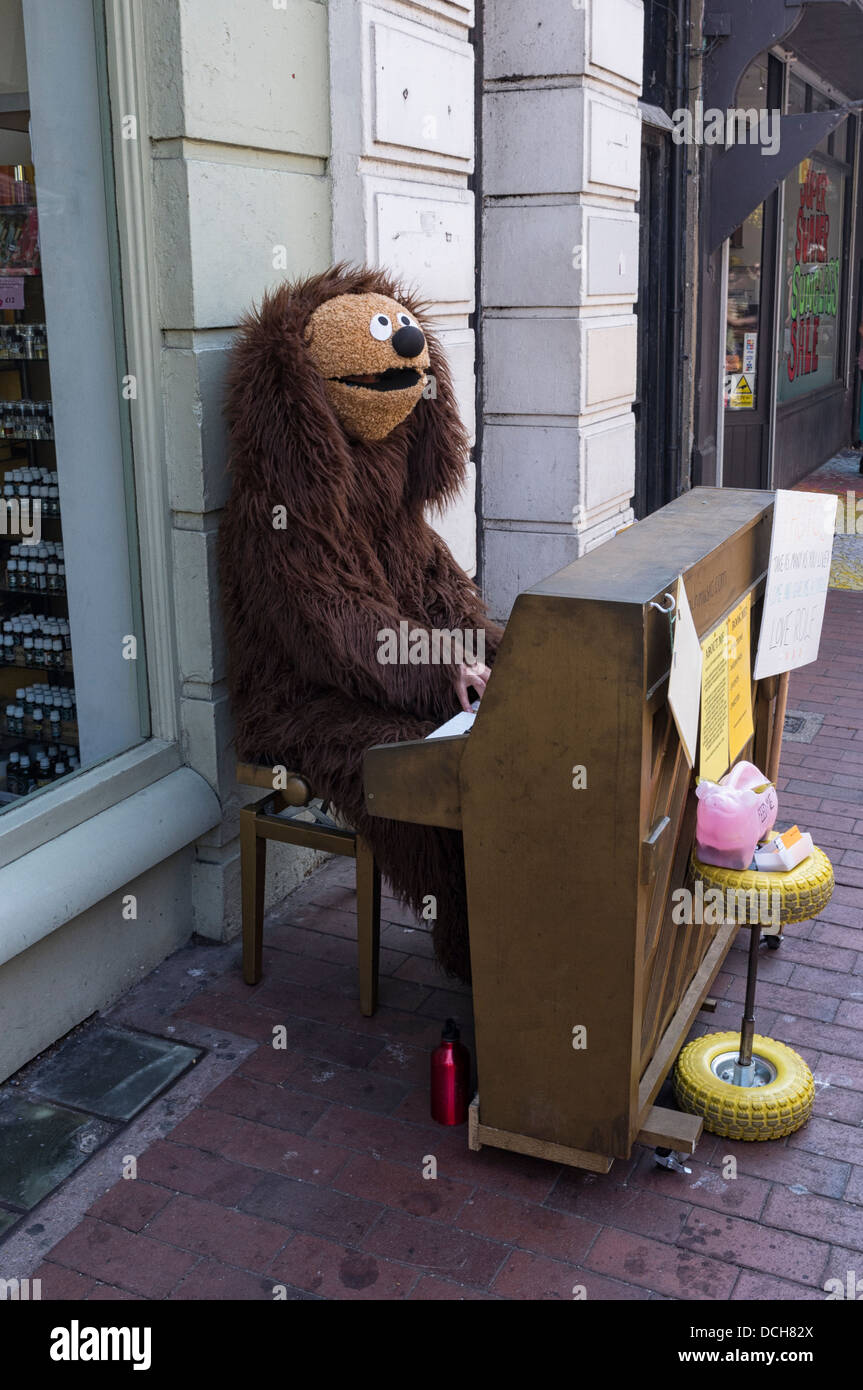A person in fancy dress (as Ralph from the Muppets) plays piano on a ...
