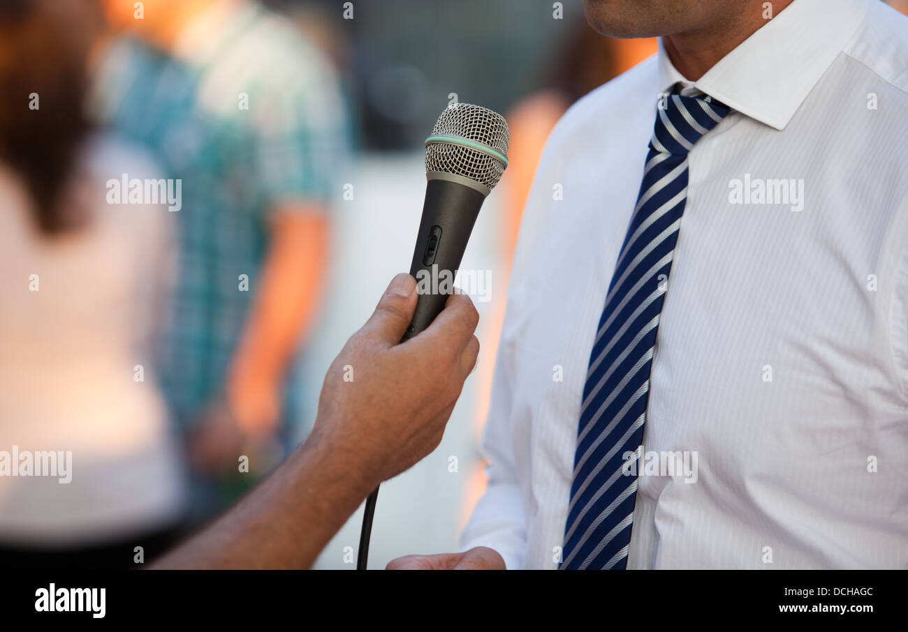 A journalist is making a interview with a microphone Stock Photo - Alamy