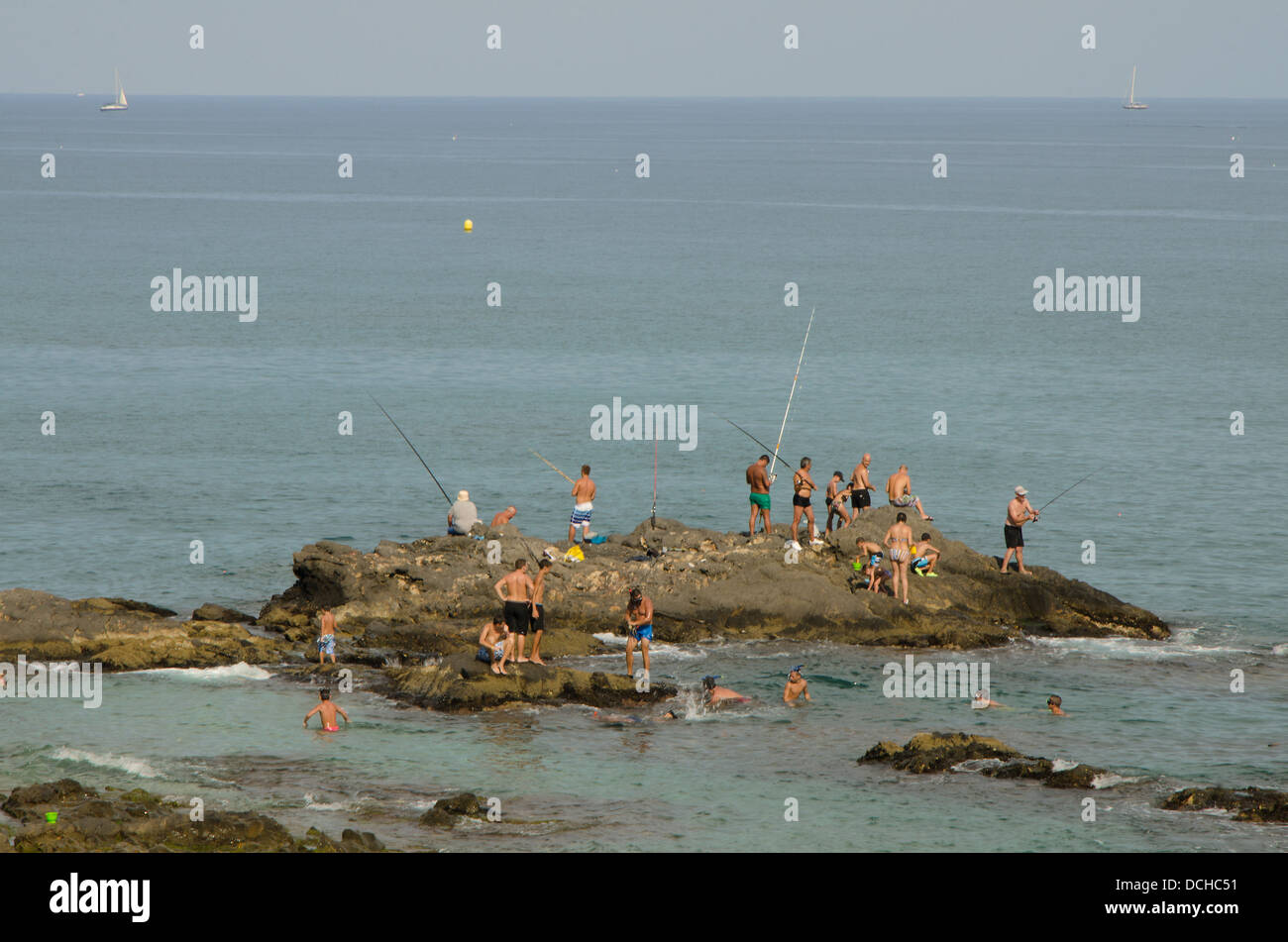 Spanish anglers fishing on a rock near Fuengirola, Costa del Sol. Spain ...