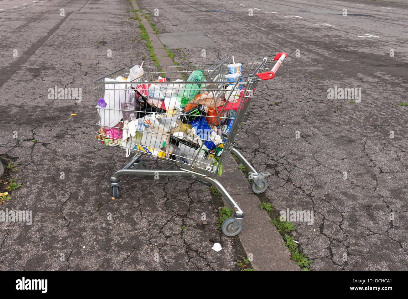 Supermarket shopping trolley filled with rubbish and left in a public ...