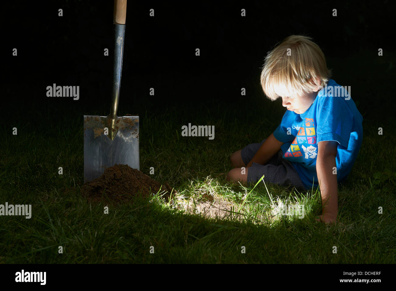 Child boy digging a treasure in magic hole in soil at dusk Stock Photo ...