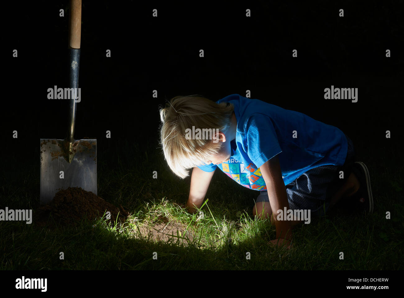 Child boy digging a treasure in magic hole in soil at dusk Stock Photo ...