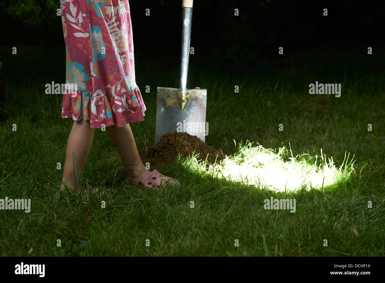 Child blond baby girl stands and digging for lighting hole in the ...
