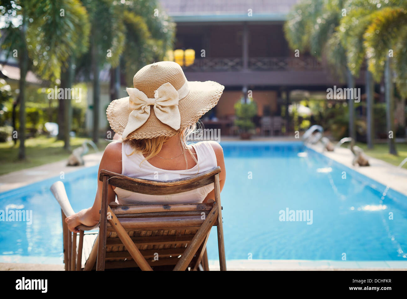 sunbath near swimming pool, fashion woman in hat Stock Photo - Alamy